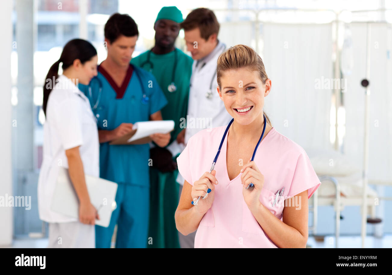Portrait of a smiling nurse with her team in the background Stock Photo ...