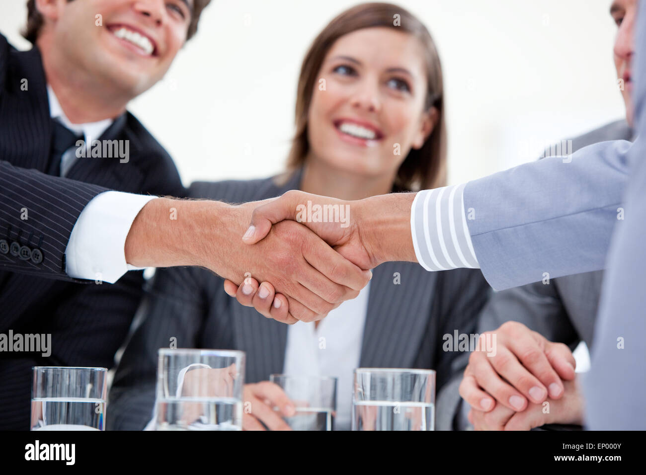 Smiling business people closing a deal Stock Photo - Alamy