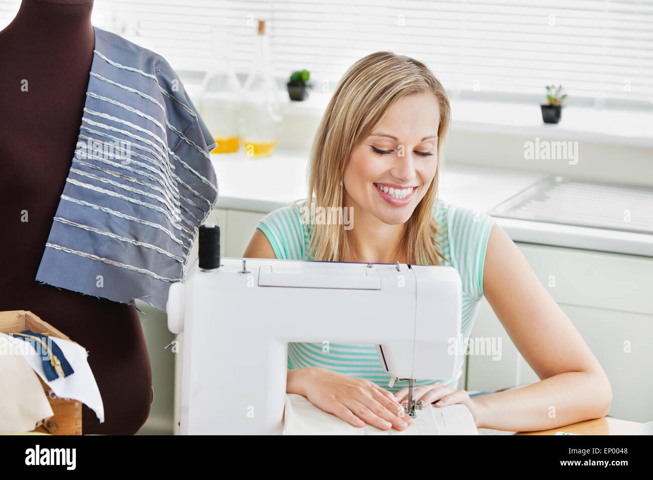 Radiant woman sewing clothes at home Stock Photo - Alamy