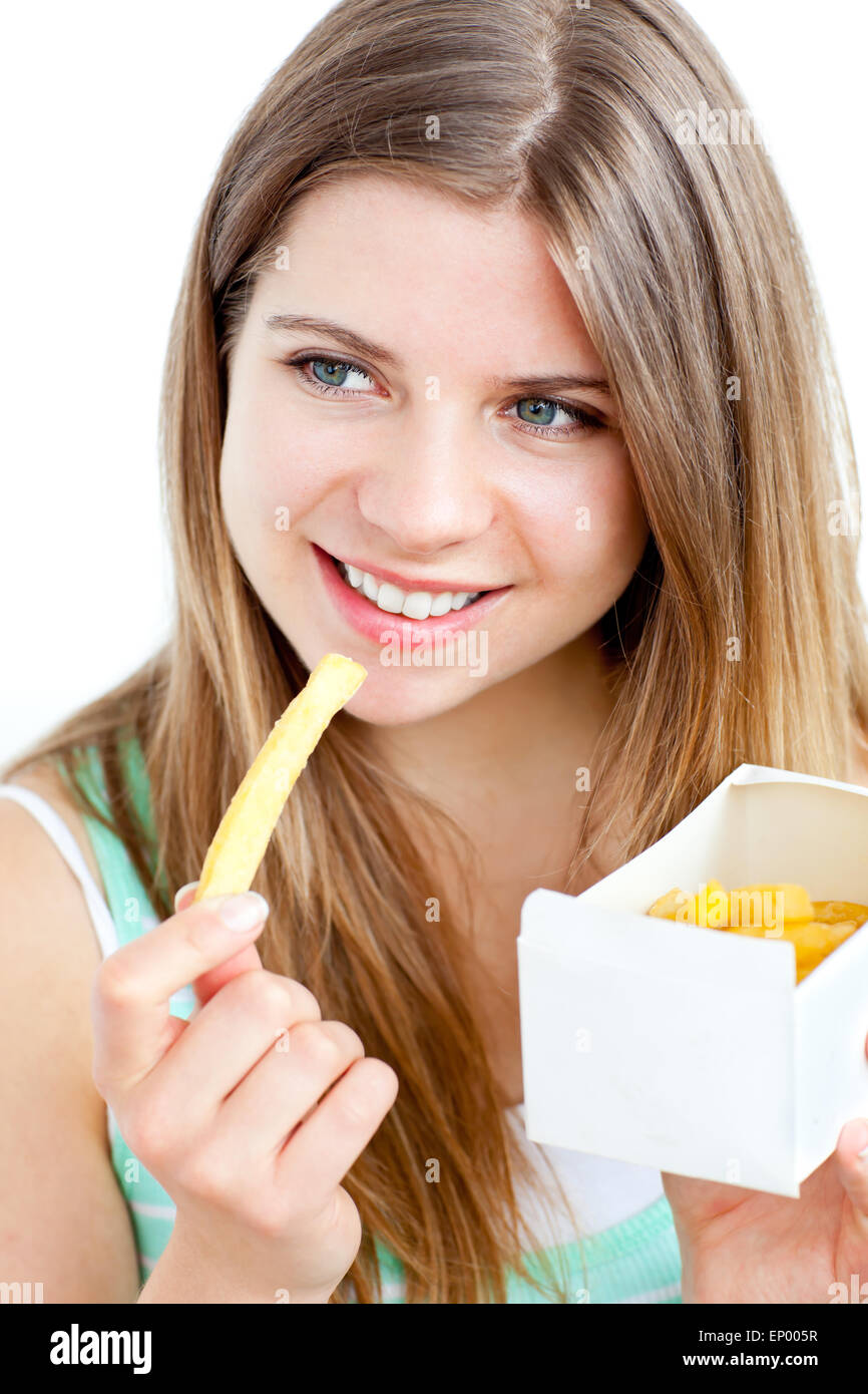 Radiant young woman eating fries against white background Stock Photo ...