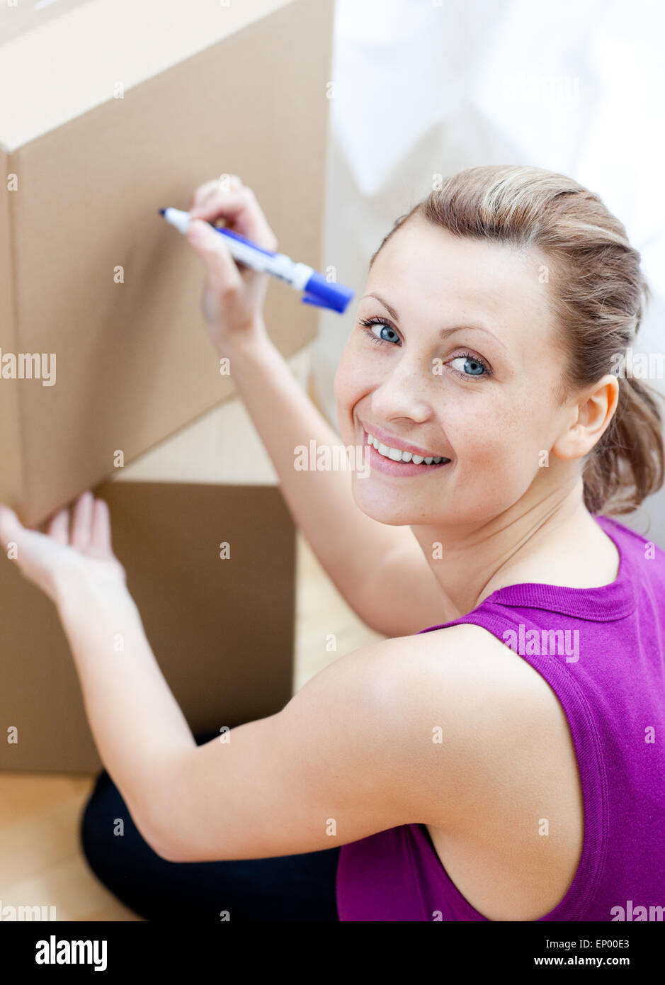 Happy woman writing on a box Stock Photo - Alamy