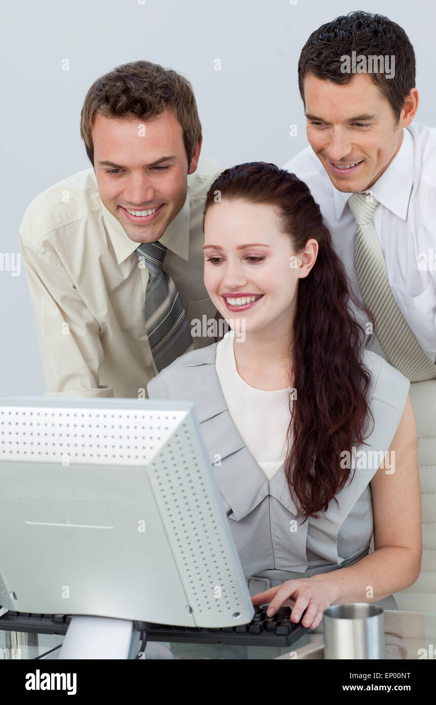 Businessmen helping a businesswoman with a computer Stock Photo - Alamy