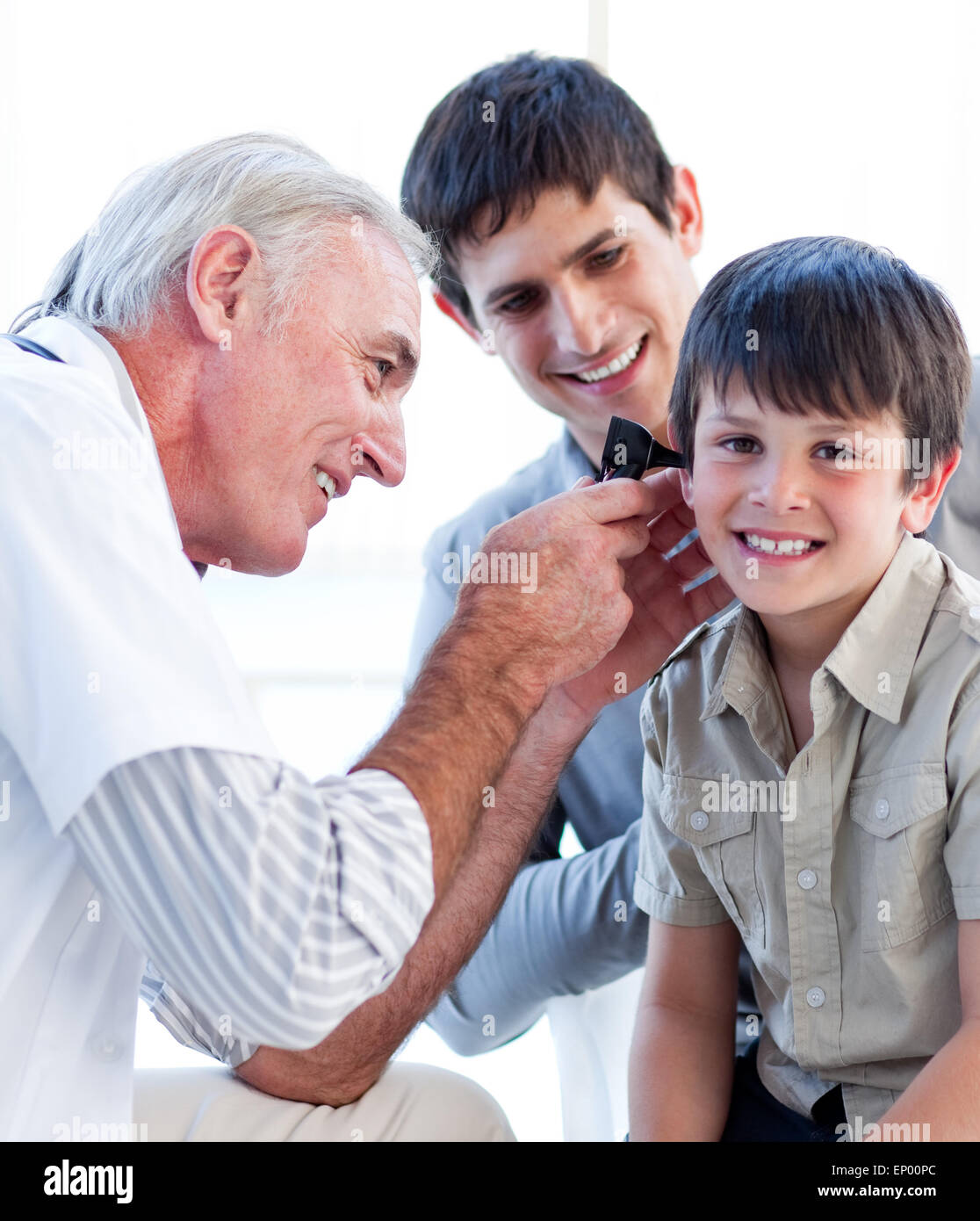 Senior doctor examining a little boy's ears Stock Photo - Alamy