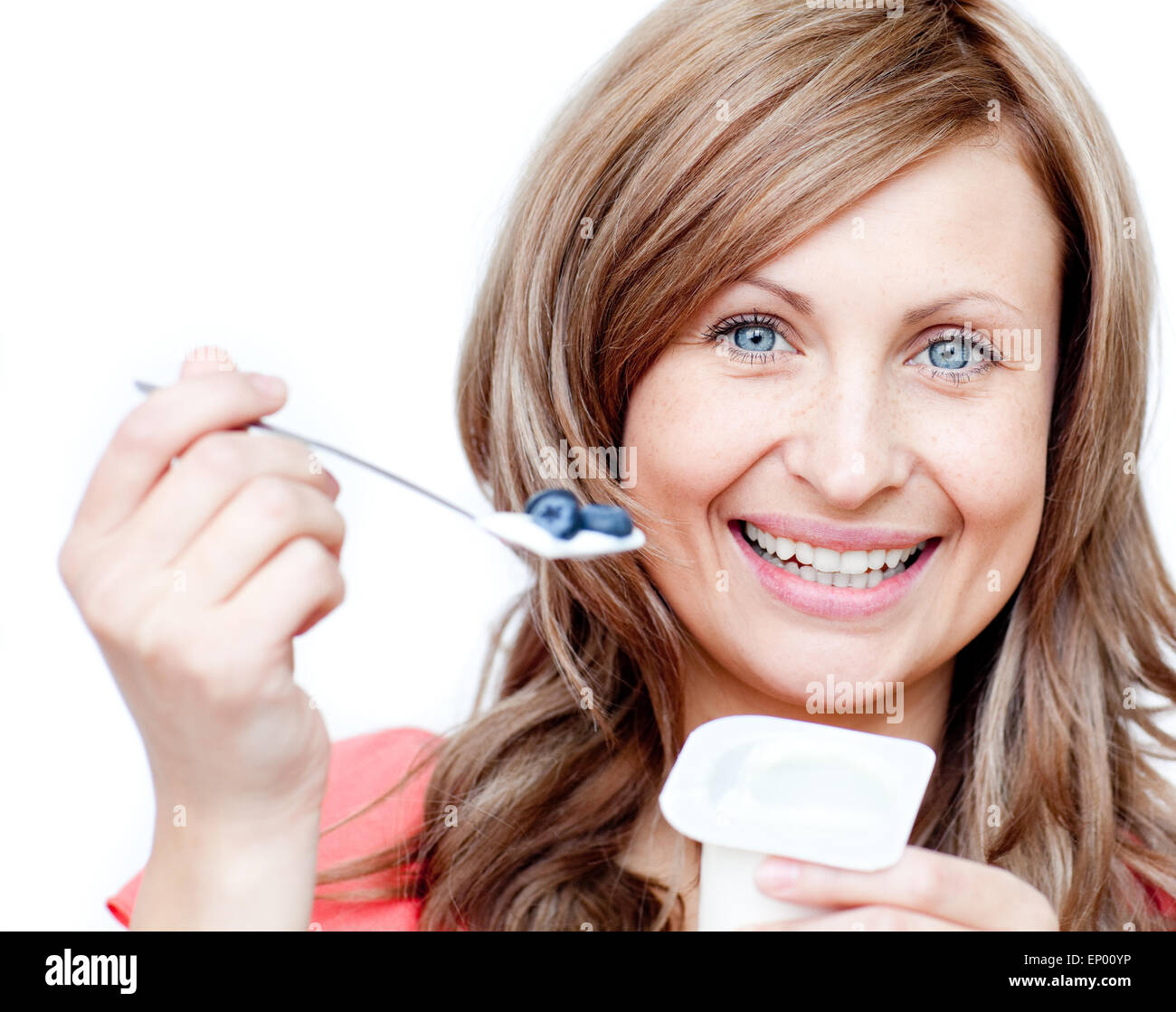 Smiling woman eating a yogurt against a white background Stock Photo ...