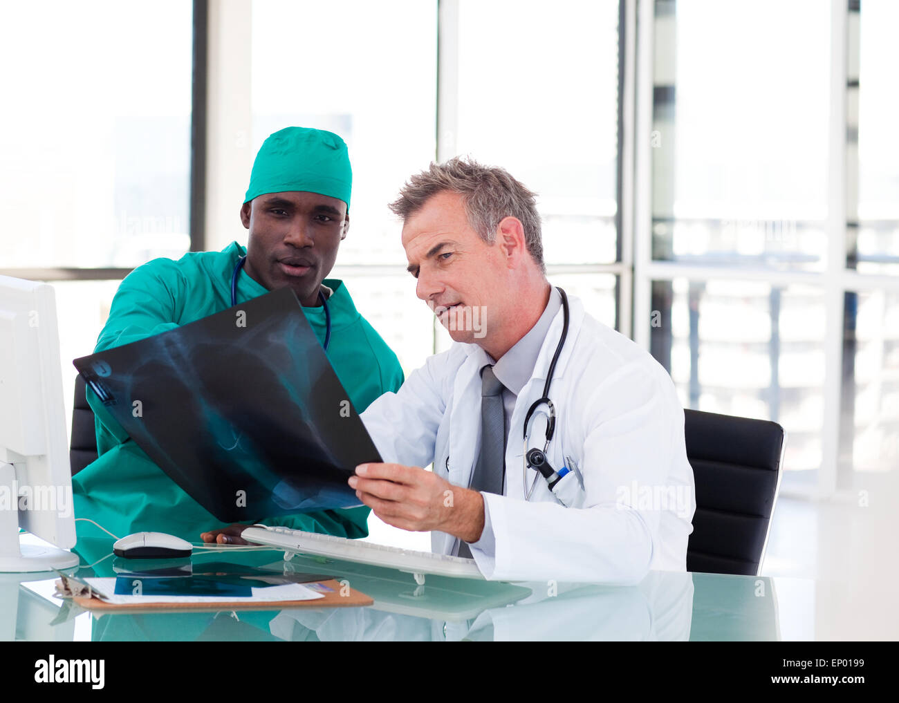 Two doctors talking about two x-rays Stock Photo - Alamy