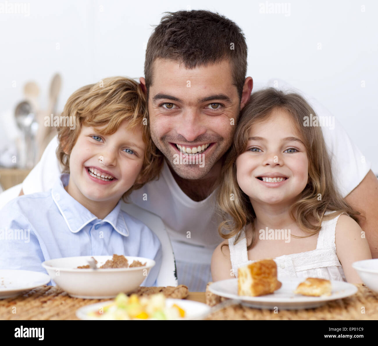 Portrait of children having breakfast with their father Stock Photo - Alamy