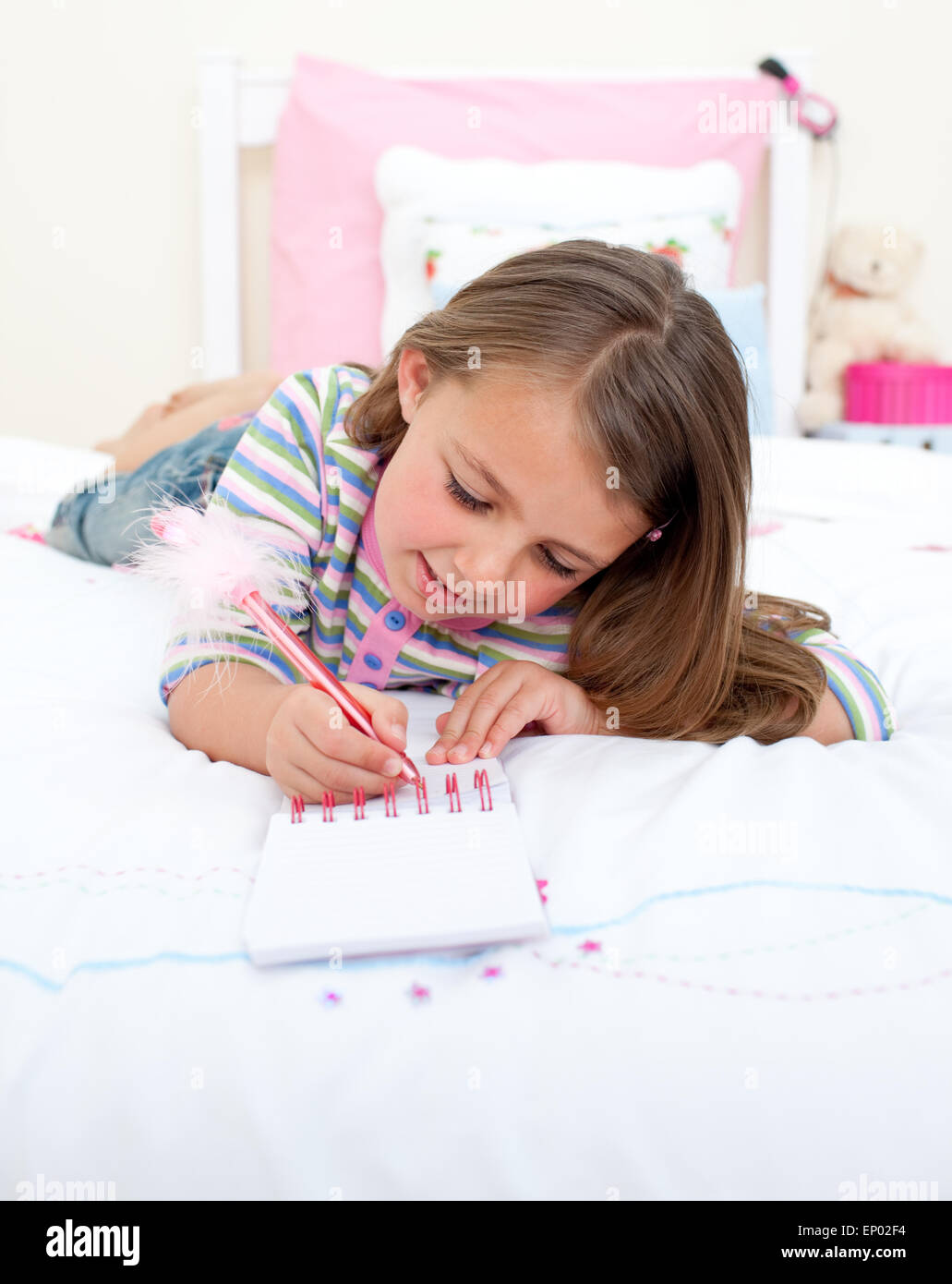 Concentrated Little girl writing on a notebook Stock Photo - Alamy