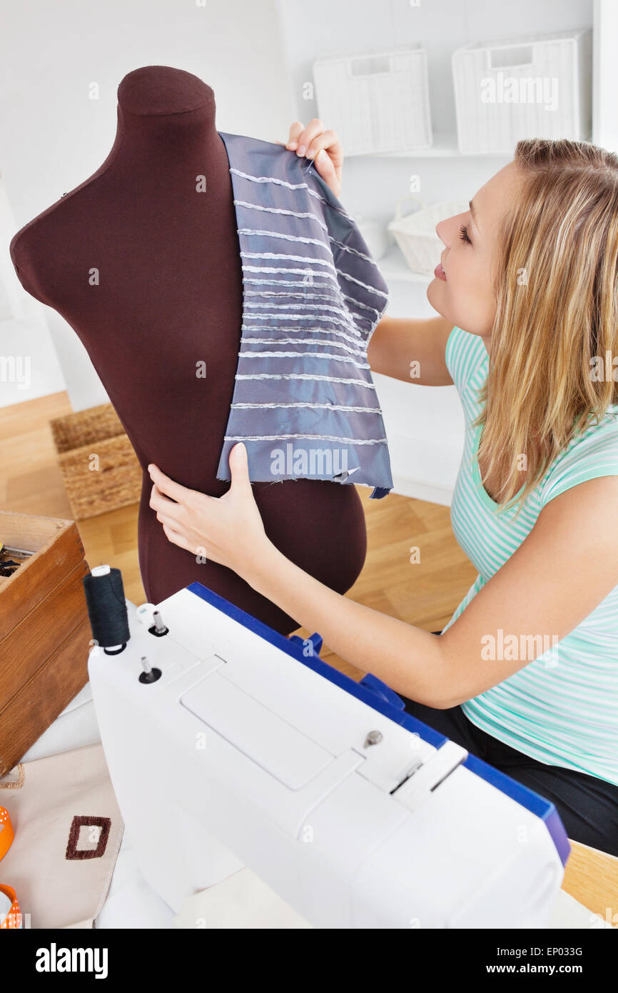 Serious young woman sewing clothes at home Stock Photo - Alamy