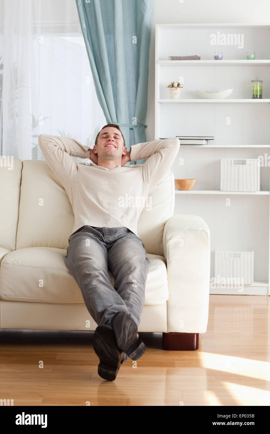 Portrait of a happy man relaxing on a couch Stock Photo - Alamy