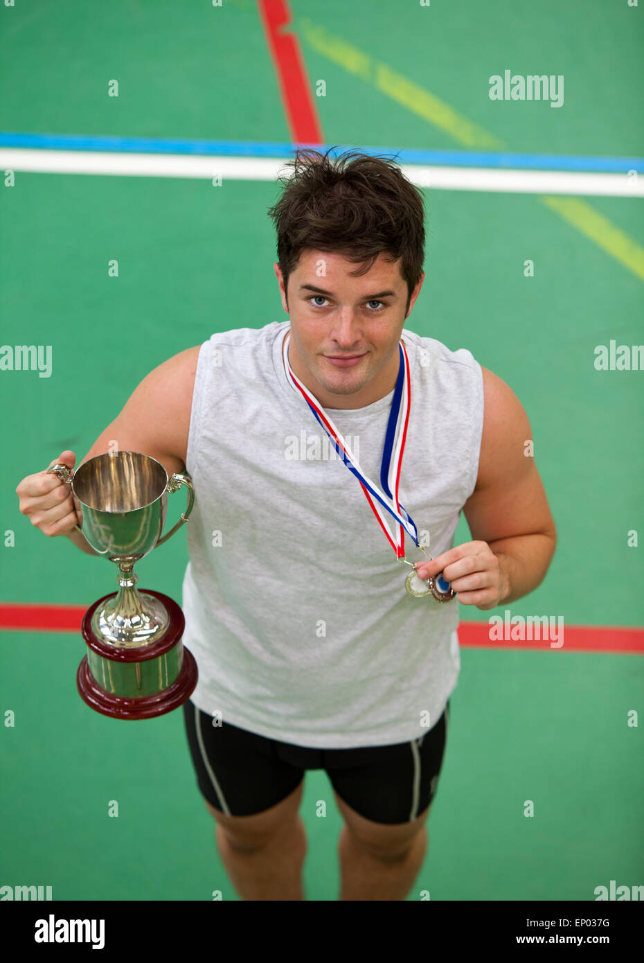 Happy young man holding a trophee and a medal in a gymnasium Stock ...