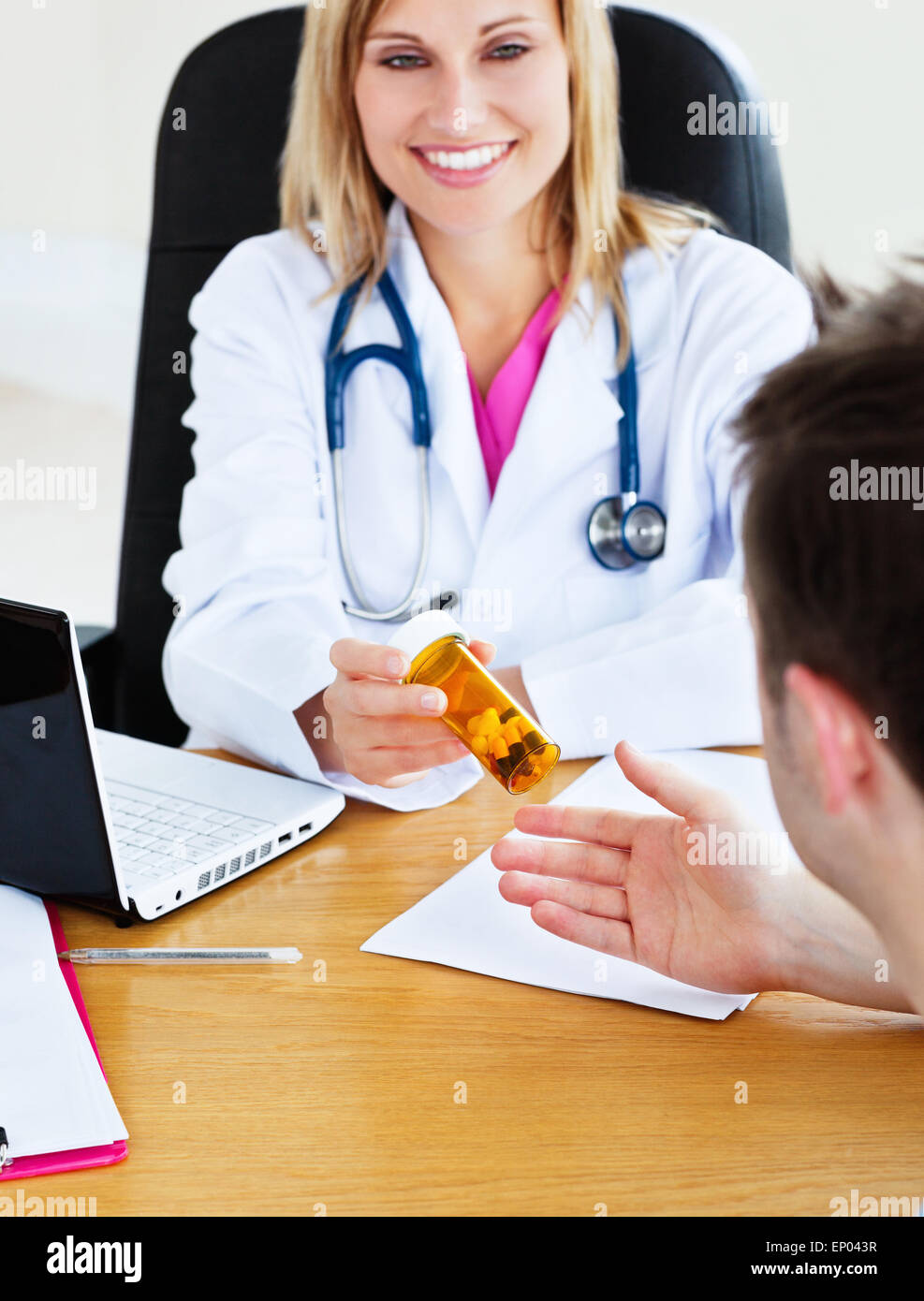 Portrait of an attractive doctor giving pills to her patient during an ...