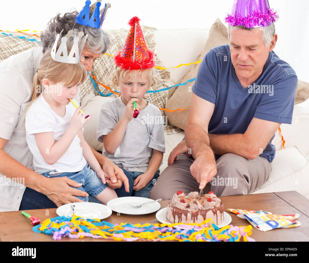 Family eating the birthday cake together Stock Photo - Alamy