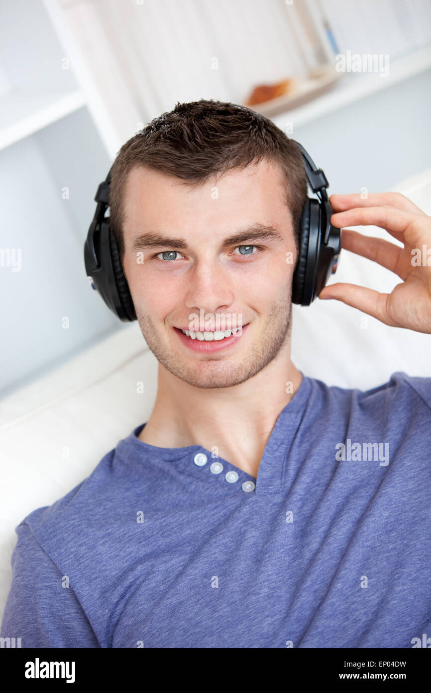 Bright Young Man Listening To Music Sitting On The Couch In The Living