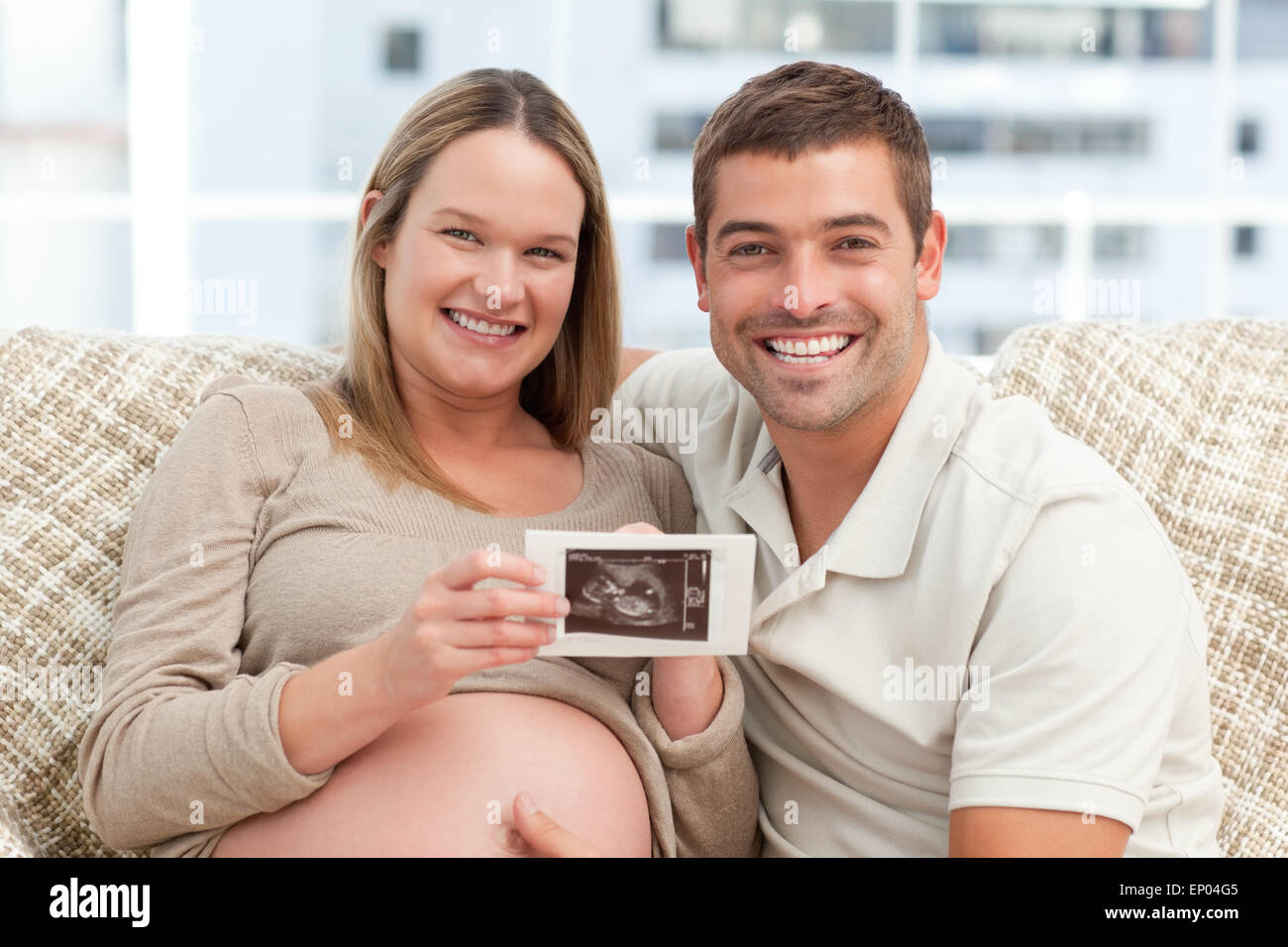 Joyful future parents looking at an echography together Stock Photo - Alamy
