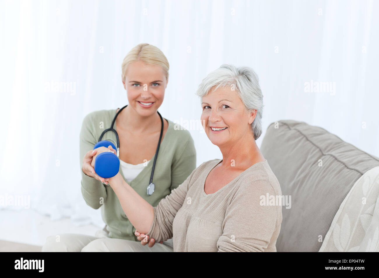 Beautiful nurse helping her patient to do exercises Stock Photo - Alamy