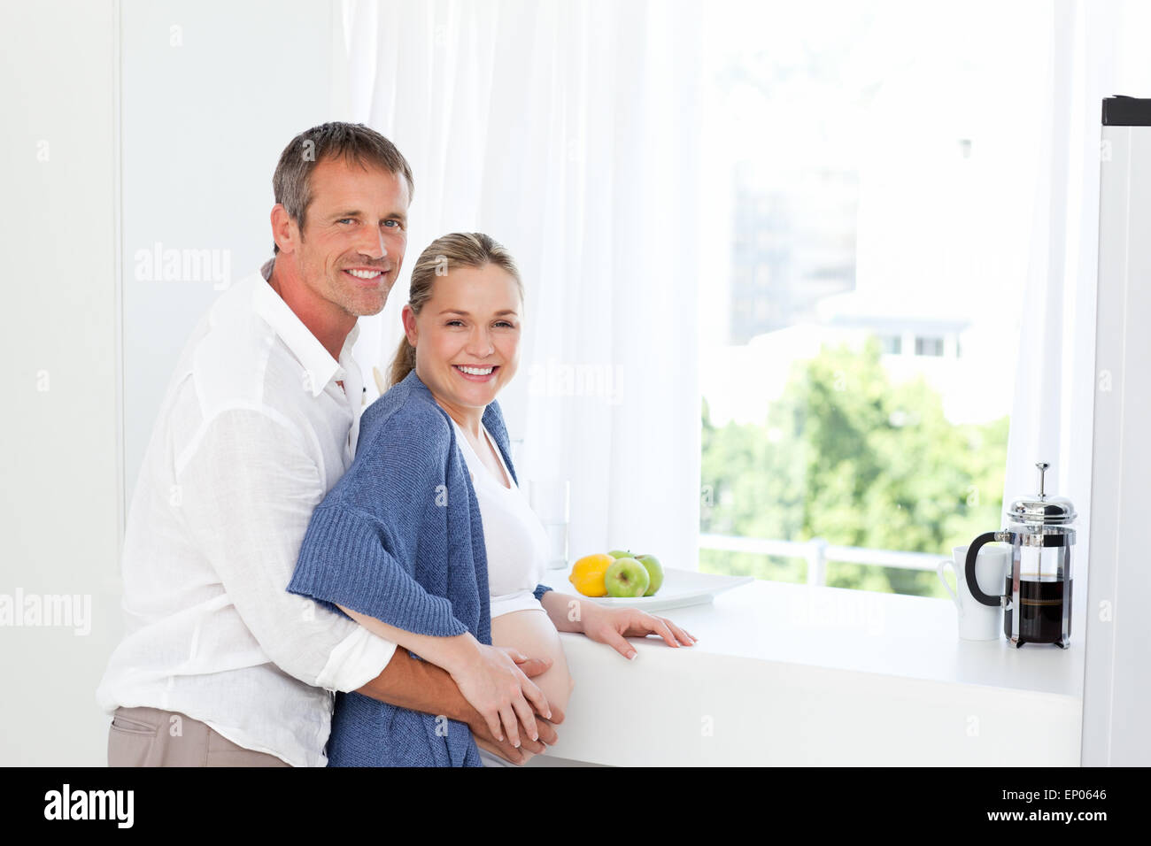 Young couple looking at the camera while they are hugging Stock Photo ...