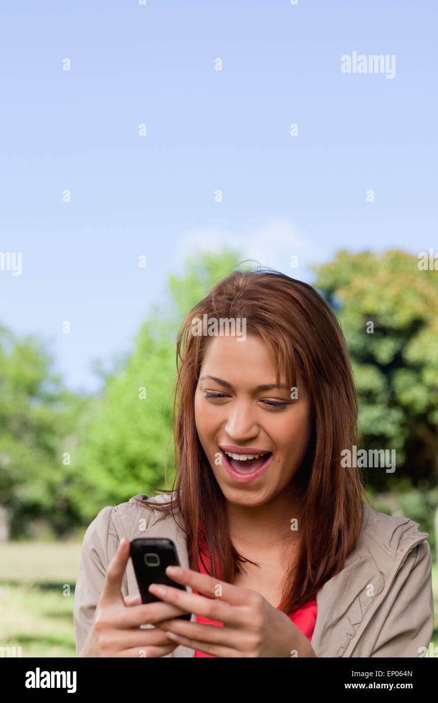 Woman with a happy expression reading a text message Stock Photo - Alamy