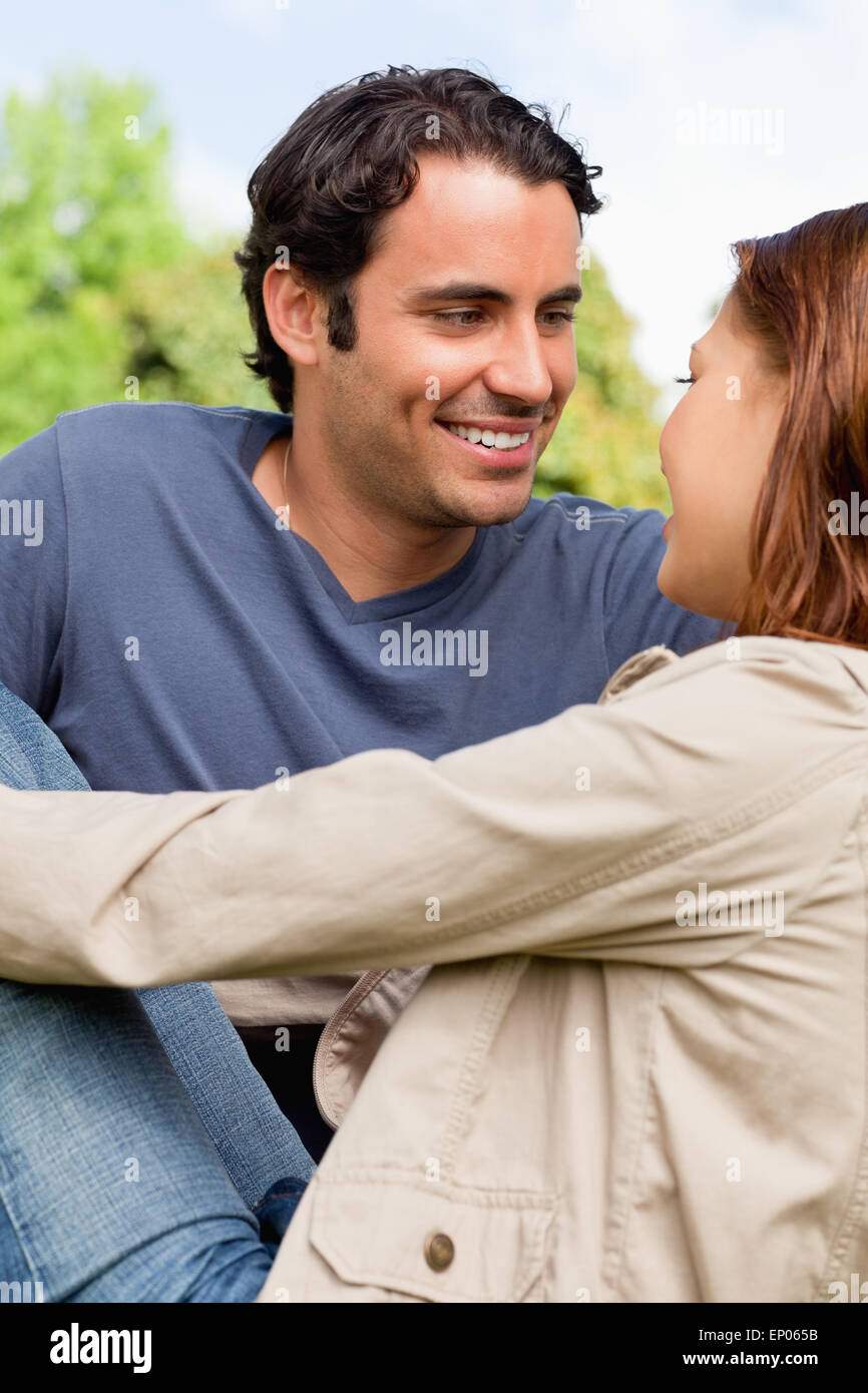 Two friends smiling as they sit next to each other on the ground Stock ...