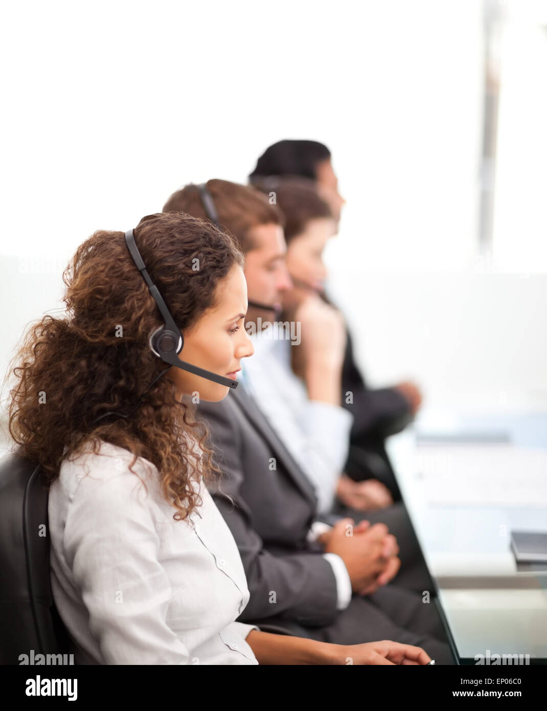 Four representatives on the phones with earpiece on Stock Photo - Alamy
