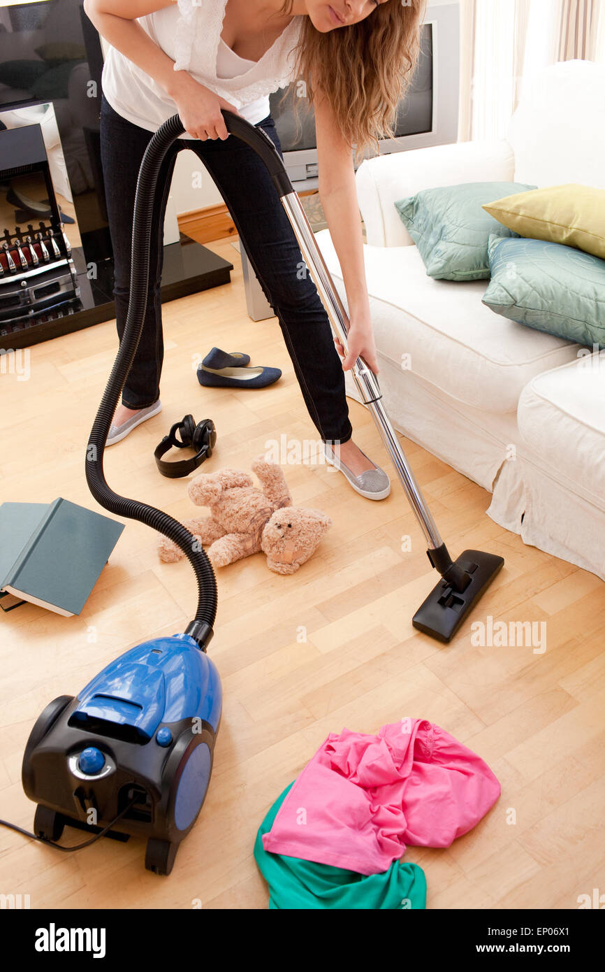 Blond young woman cleaning the living-room Stock Photo - Alamy