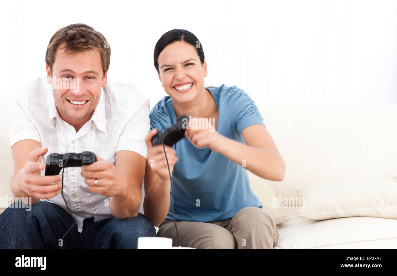Excited woman playing video games with her boyfriend on the sofa Stock ...