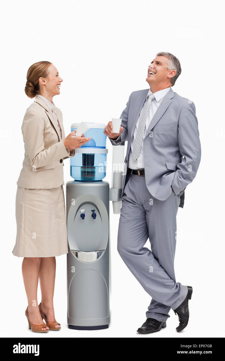 People in suit laughing next to the water dispenser Stock Photo - Alamy