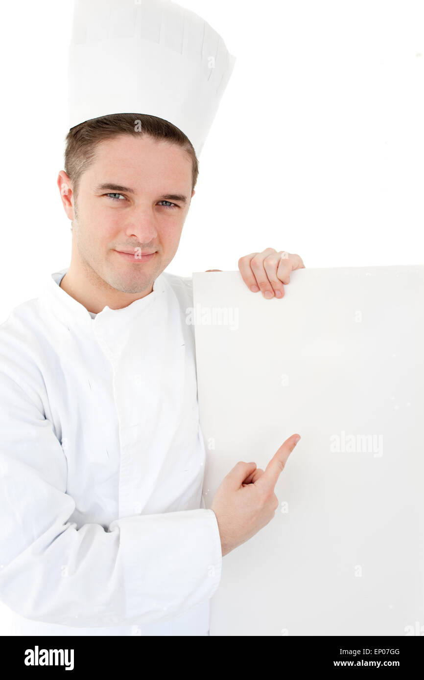 Confident young cook showing on a white paper against white background ...