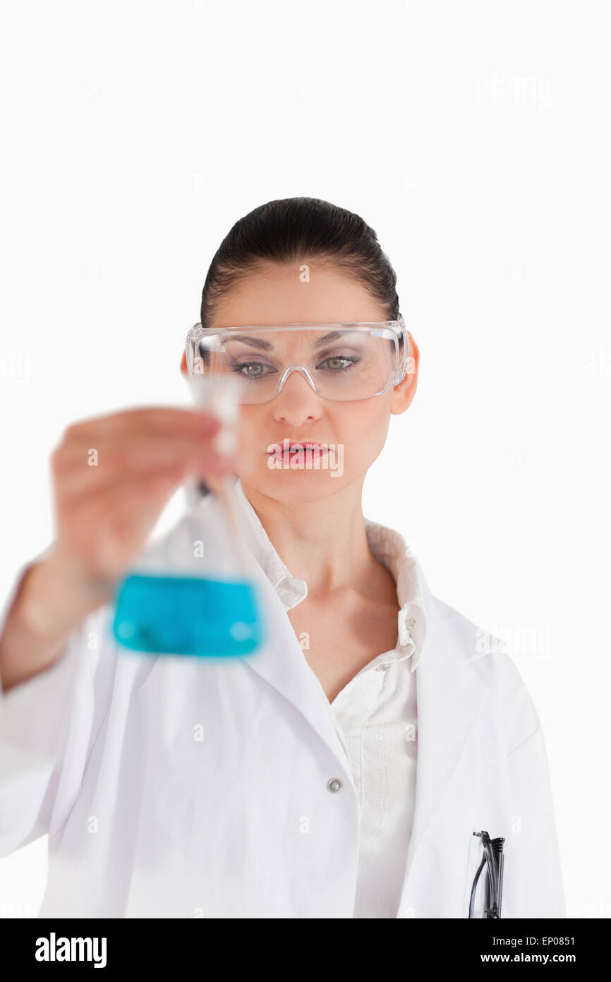 Female scientist wearing safety glasses and holding a blue flask Stock ...