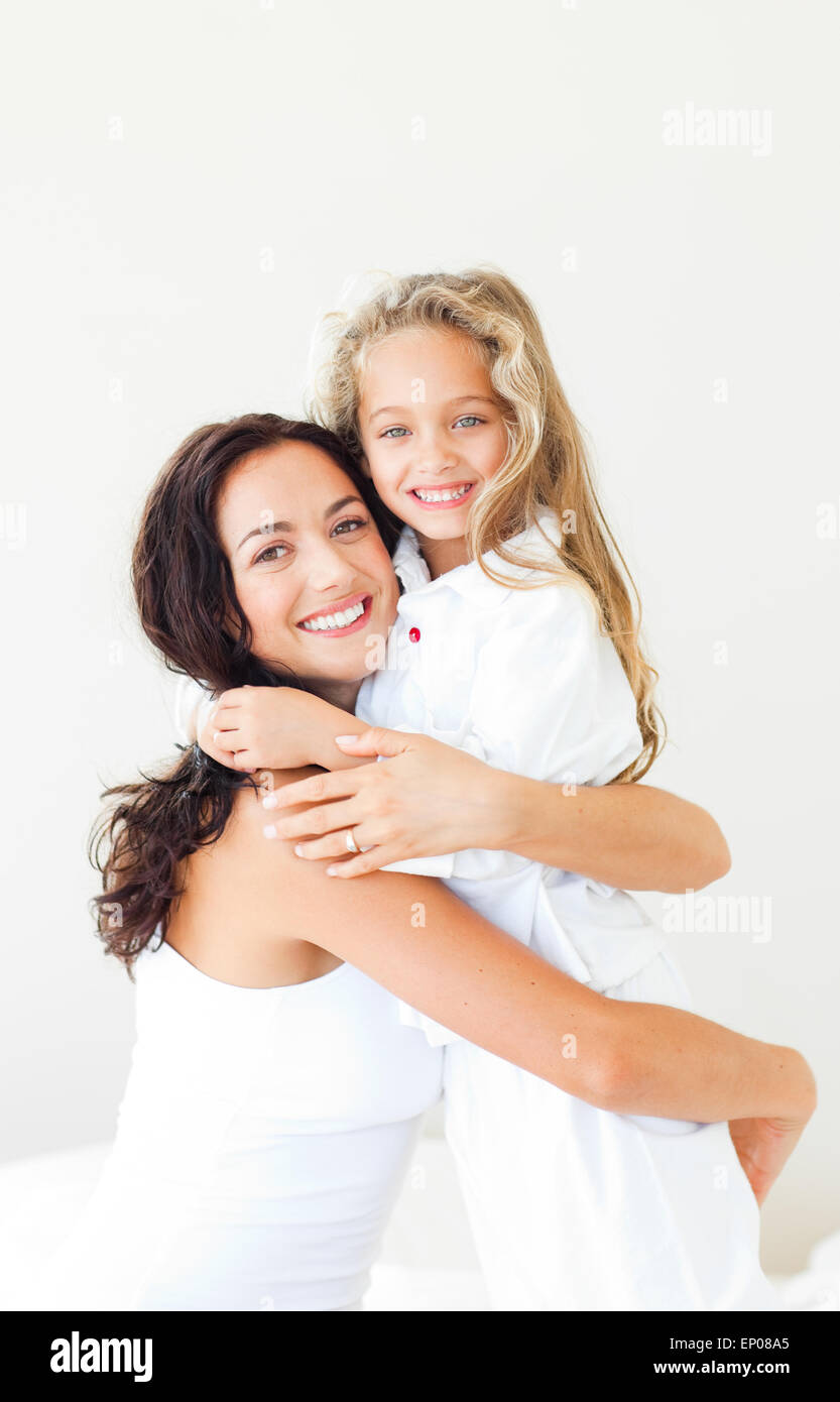Delighted mother and daughter on a white bed Stock Photo - Alamy