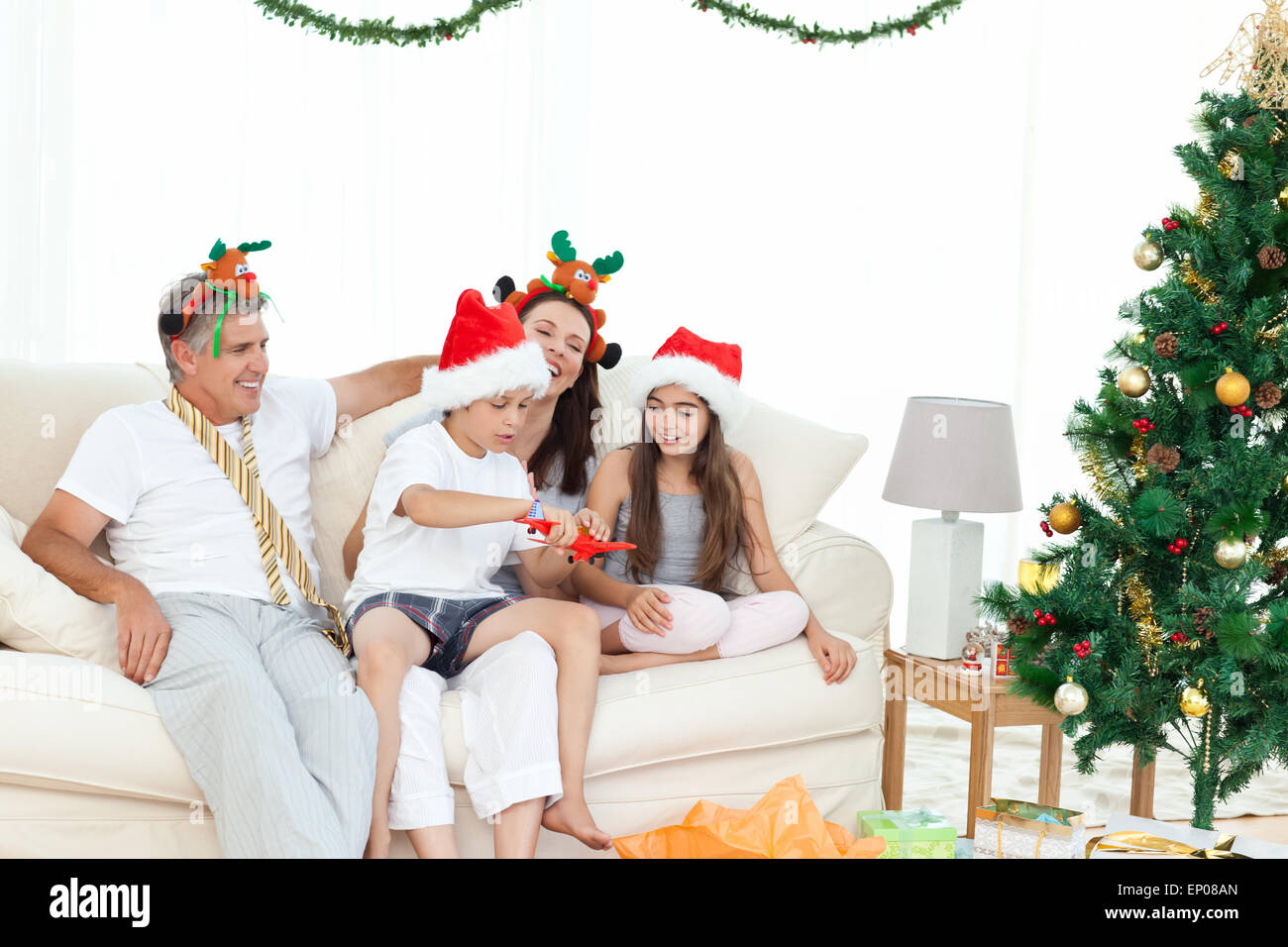 Family during Christmas day looking at their presents Stock Photo - Alamy