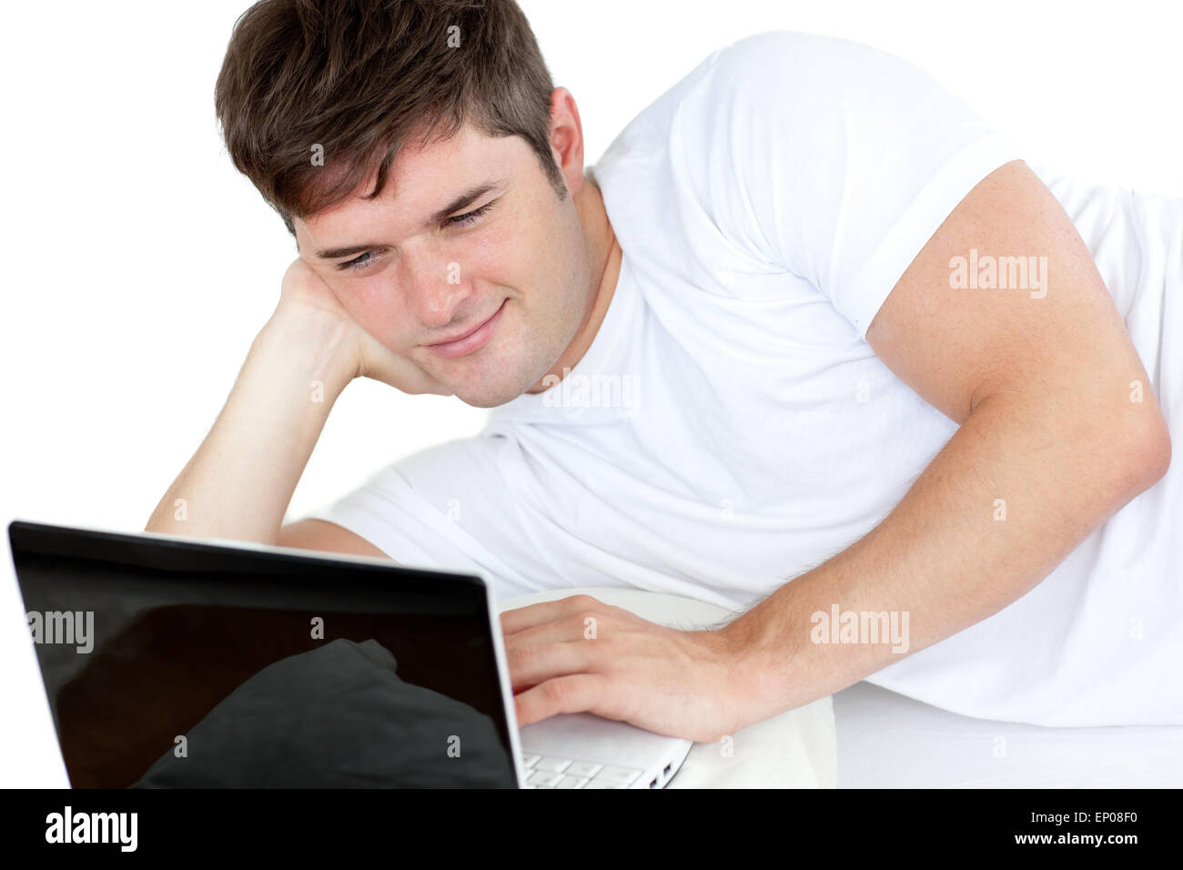 smart man working on his computer lying on the floor against a white ...