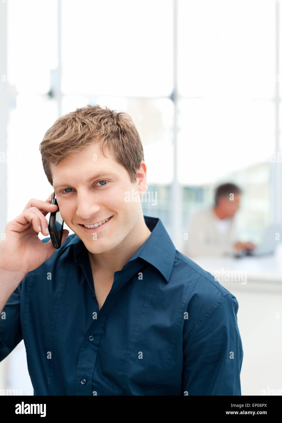 Happy businessman phoning in his office Stock Photo - Alamy
