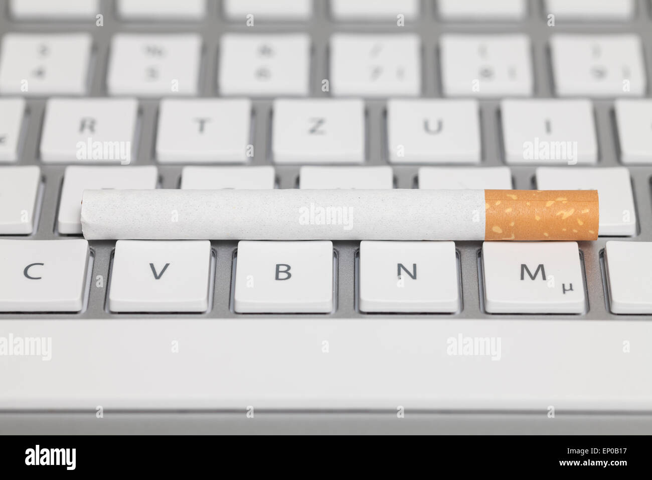 Cigarette on keyboard Stock Photo - Alamy