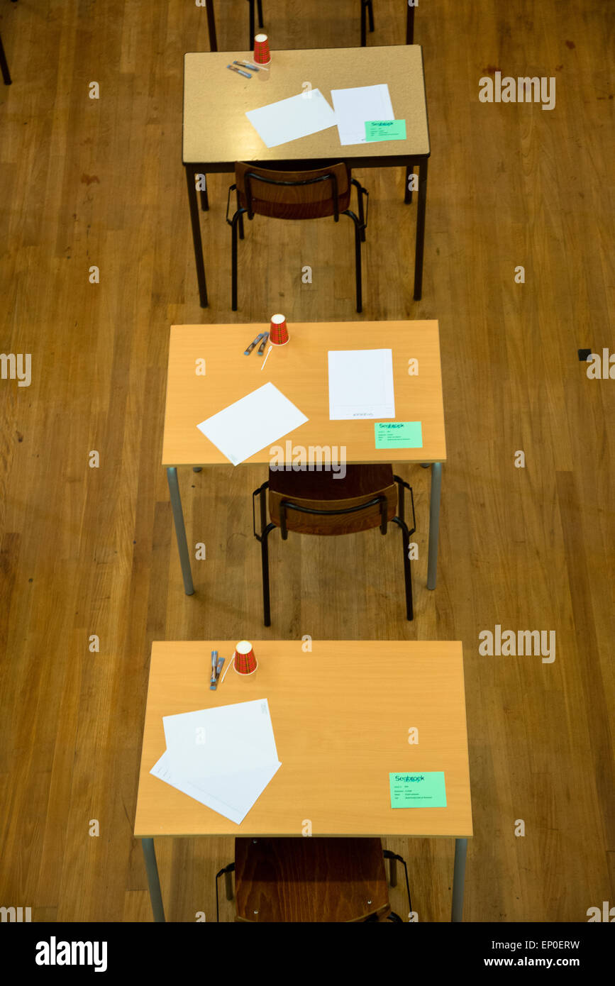 rows of tables and chairs with paper and cups waiting for the exam at ...