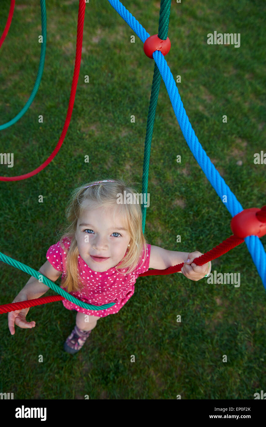 Portrait of child young blond girl climbing ropes on playground Stock ...