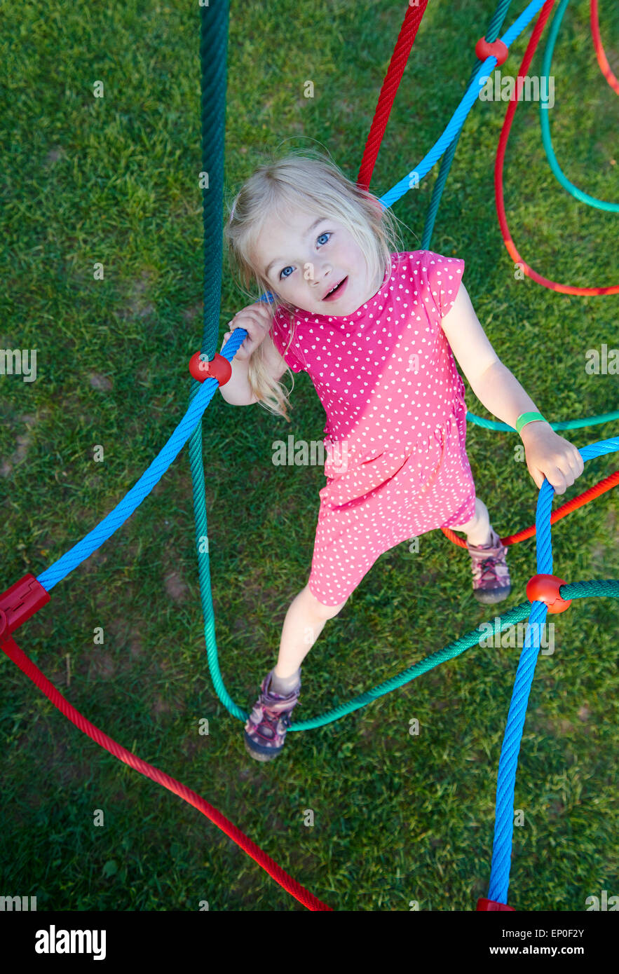 Portrait of child young blond girl climbing ropes on playground Stock ...