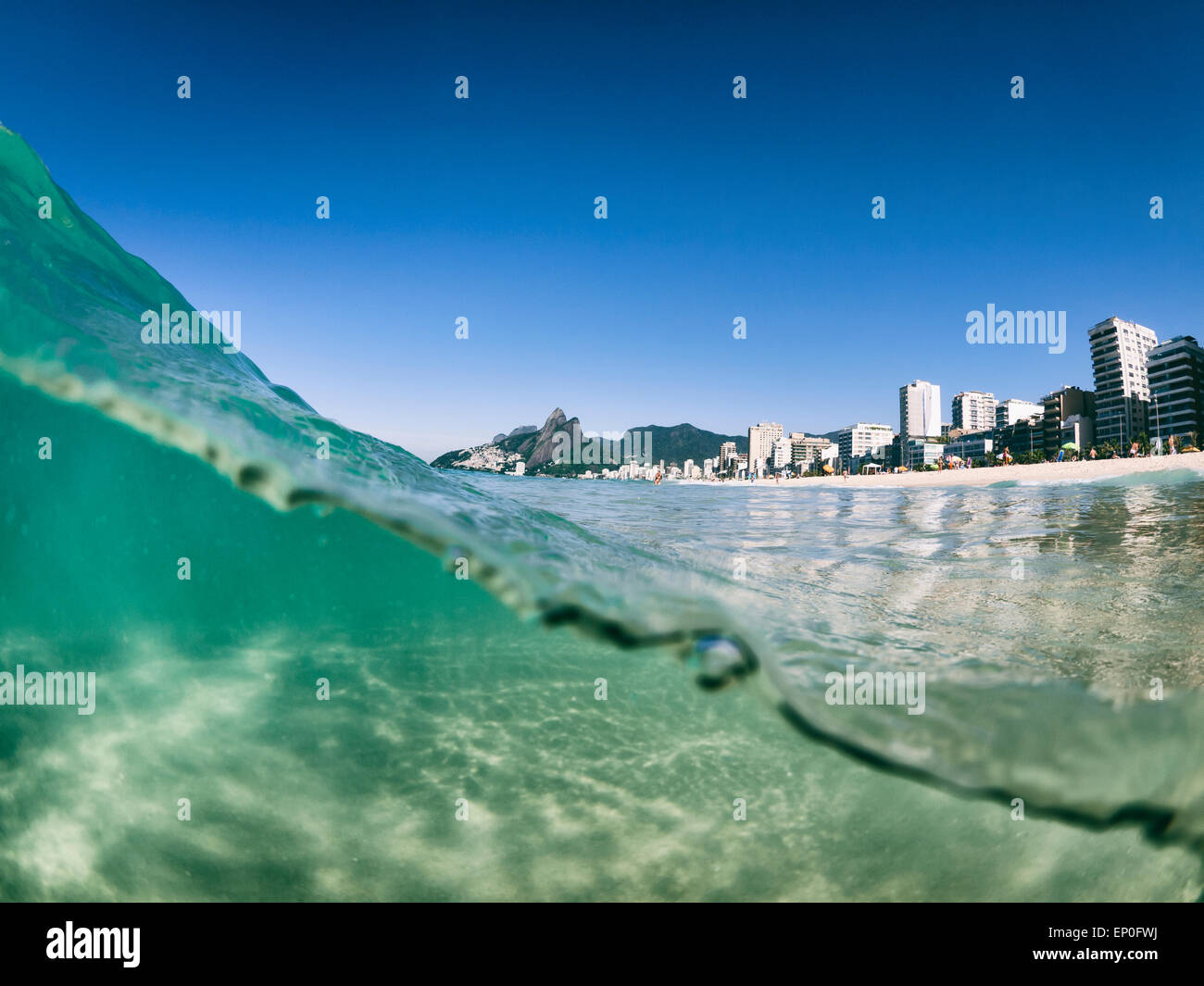 Over-under underwater view of clear green tropical waters off the shore ...