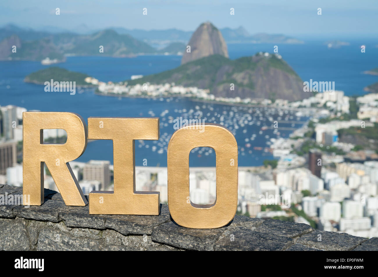 Golden RIO sign standing at bright overlook view of Rio de Janeiro city ...