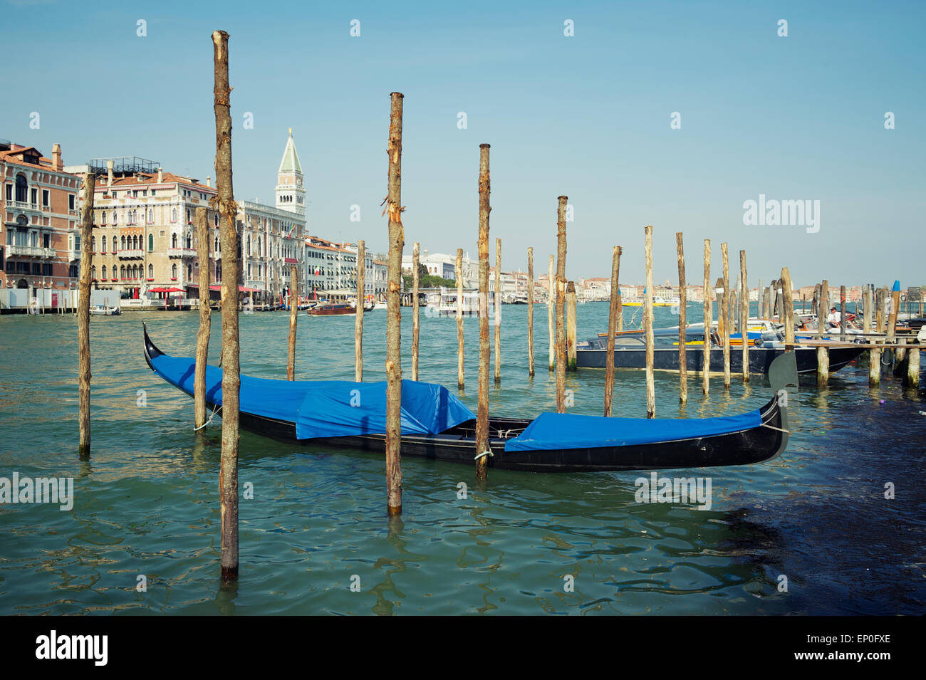 Traditional Venetian gondola covered in blue fabric moored on the Grand ...