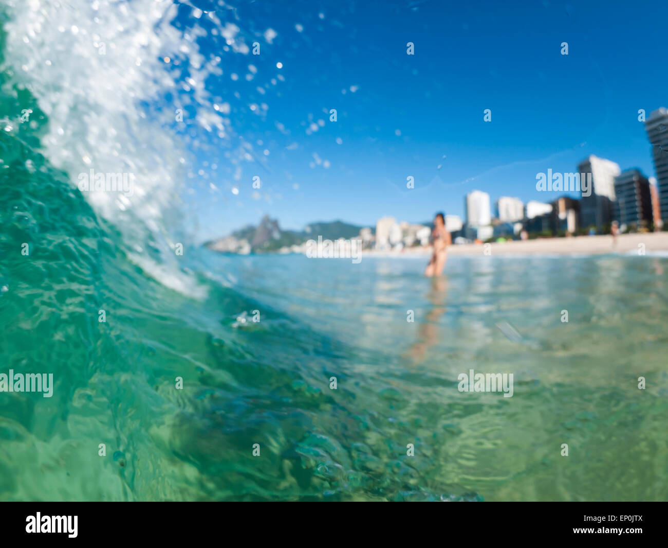 View of clear green tropical wave crashing off the shore of Ipanema ...