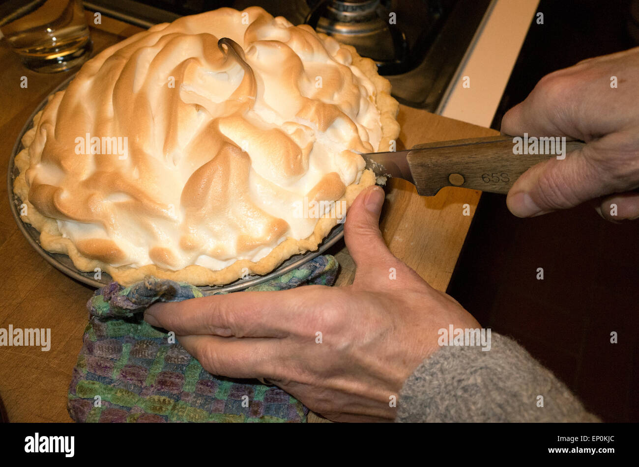 Cutting into a Baked Alaska dessert consisting of ice cream and cake ...