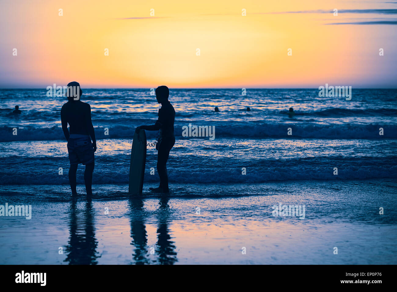 Young people standing on the shore on Cavancha beach at sunset in ...