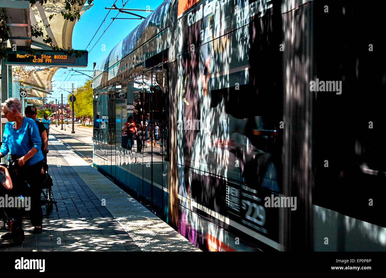 People exiting train station with train passing by Stock Photo - Alamy