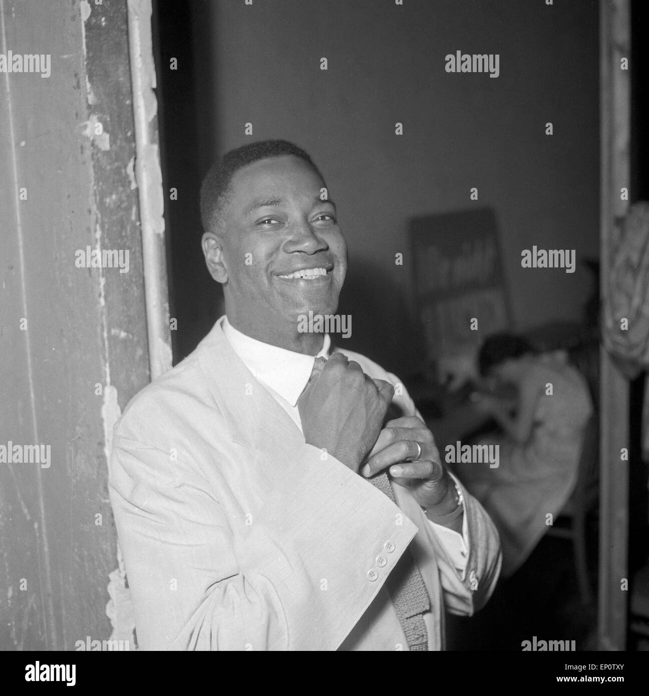 Der US-amerikanische Sänger Kenneth Spencer richtet sich seine Krawatte ...