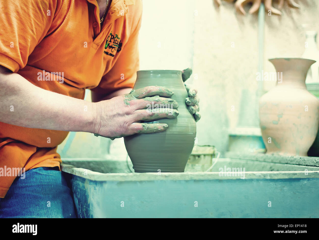 On a rotating pottery wheel wizard manually manufactures ceramic vase ...