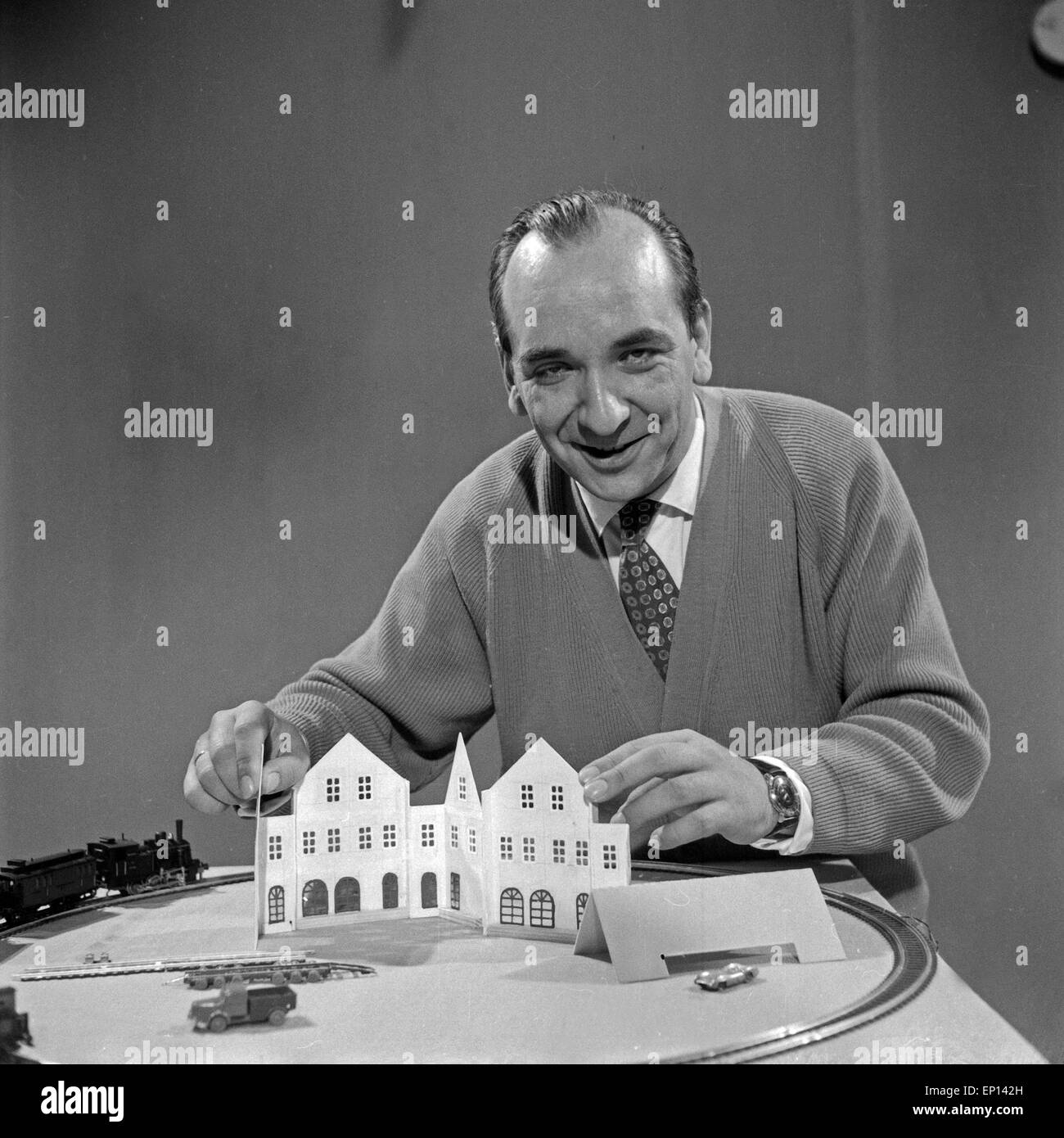 Ein Mann spielt mit seiner Modelleisenbahn, Deutschland 1950er Jahre. A ...