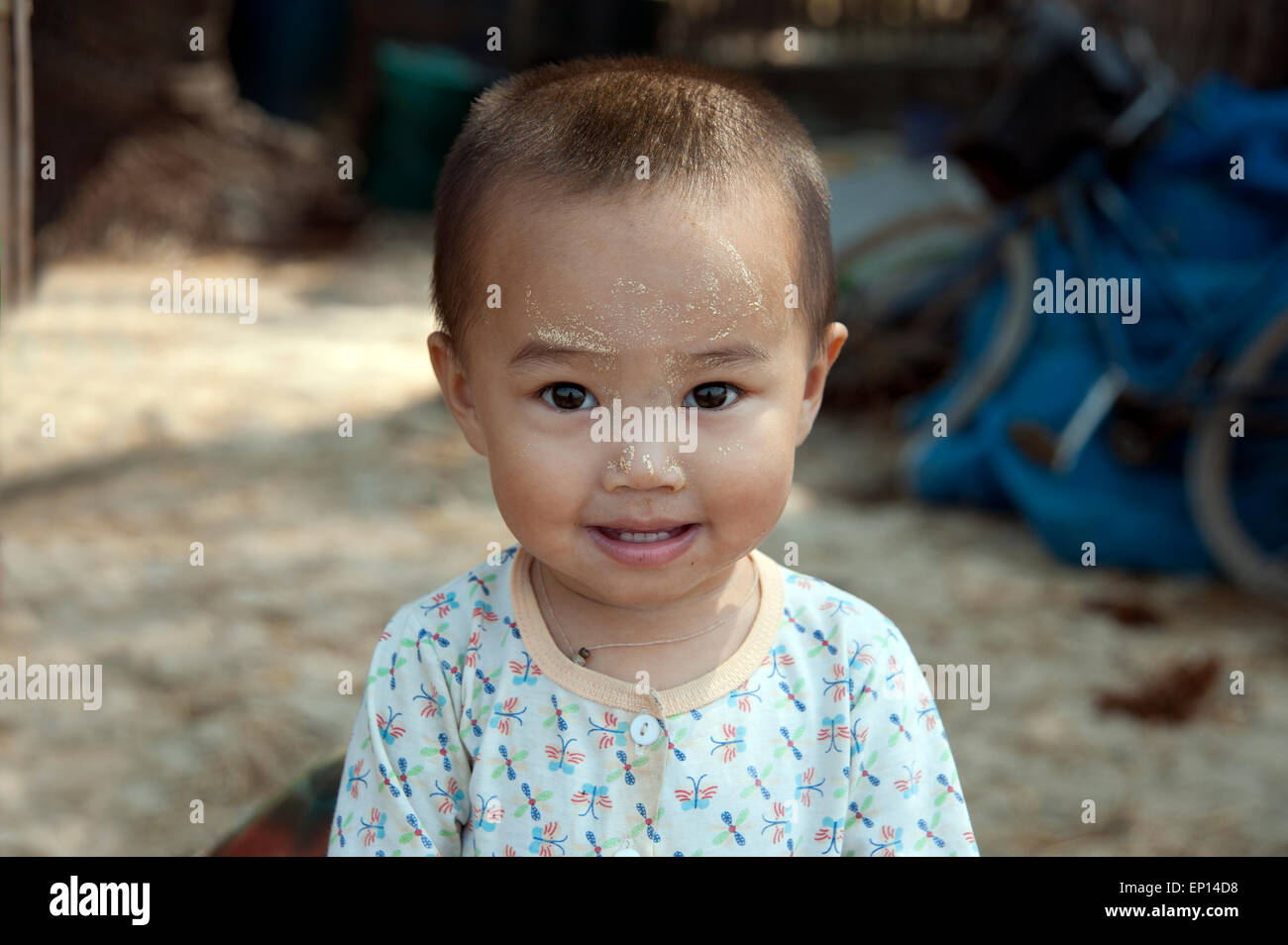 A portrait of a happy smiling young Burmese baby boy with sandalwood ...
