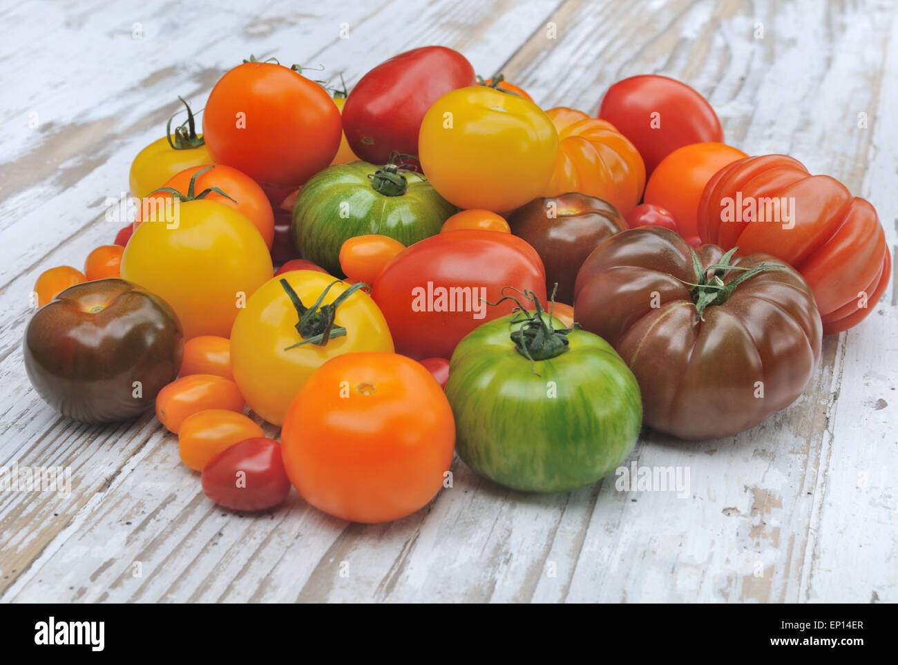 differents color varieties of tomatoes on a wooden white table Stock ...