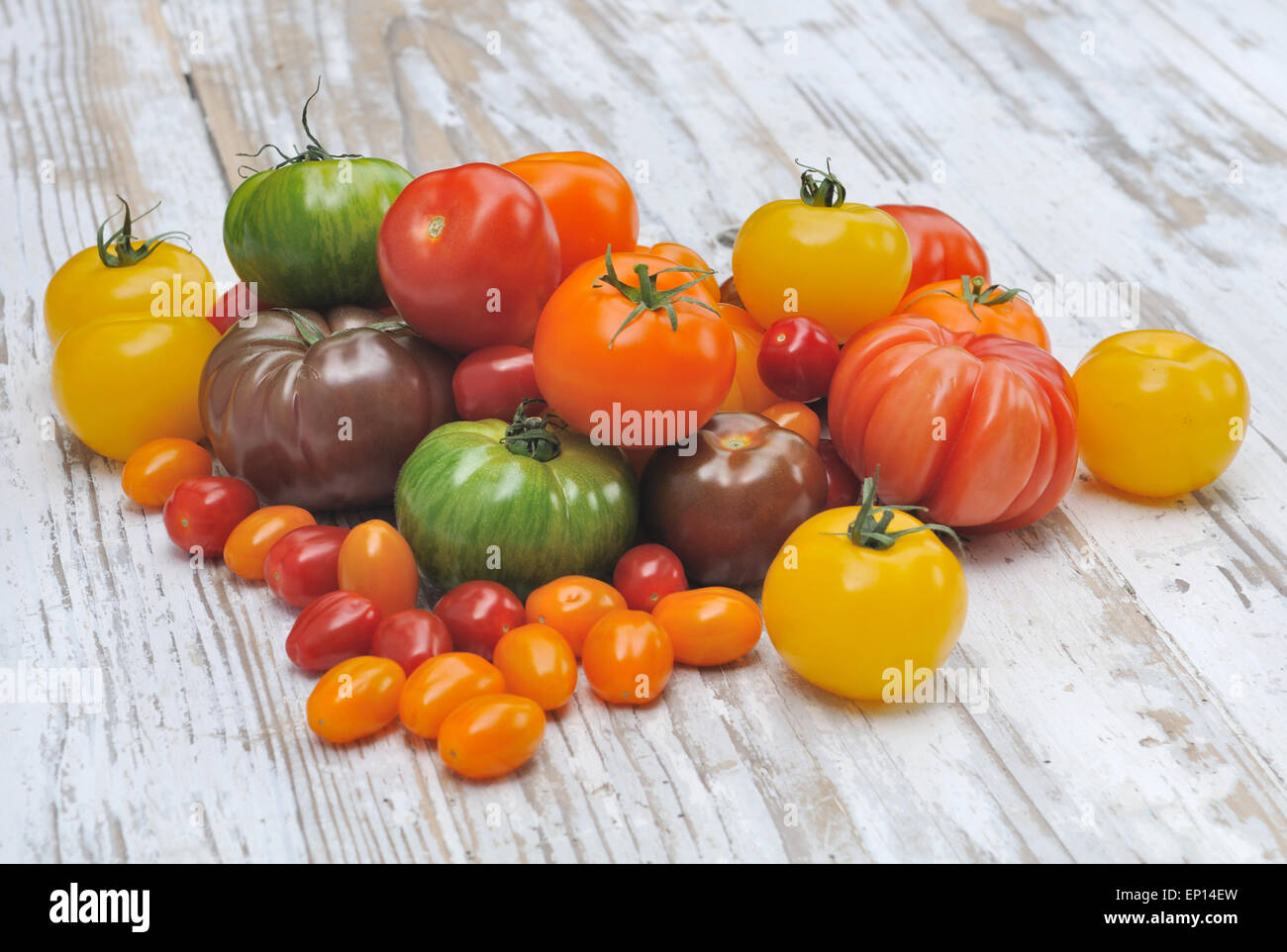 differents color varieties of tomatoes on a wooden white table Stock ...