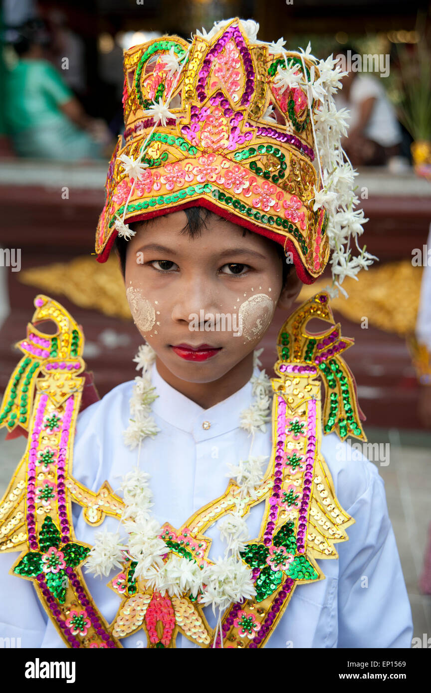 Portrait of a Burmese boy dressed in traditional costume wearing face ...
